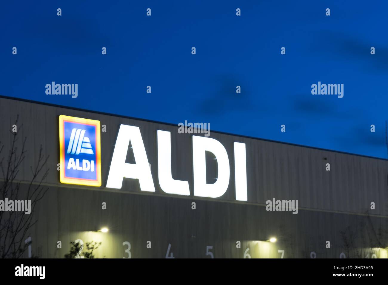 Store logo at night for ALDI supermarket England UK Stock Photo - Alamy