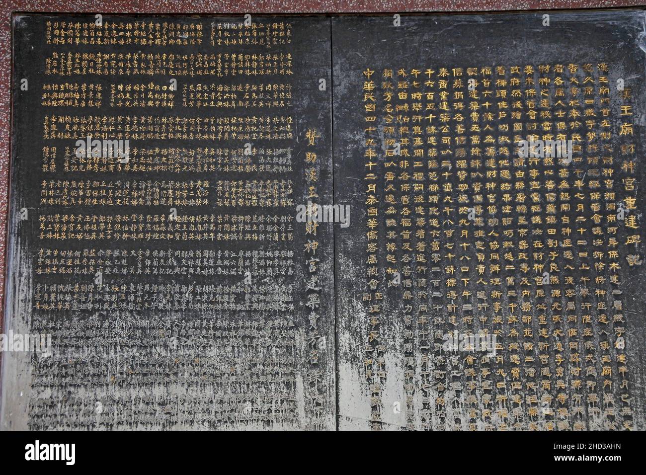 A close up view of embossed gold Chinese characters on a marble plaque ...