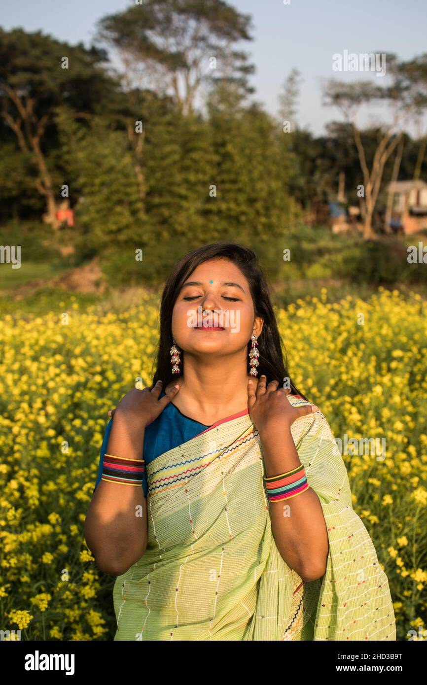 A woman poses for a photo at a yellow Mustard Field on the outskirts of Dhaka. Mustard is a cool ...