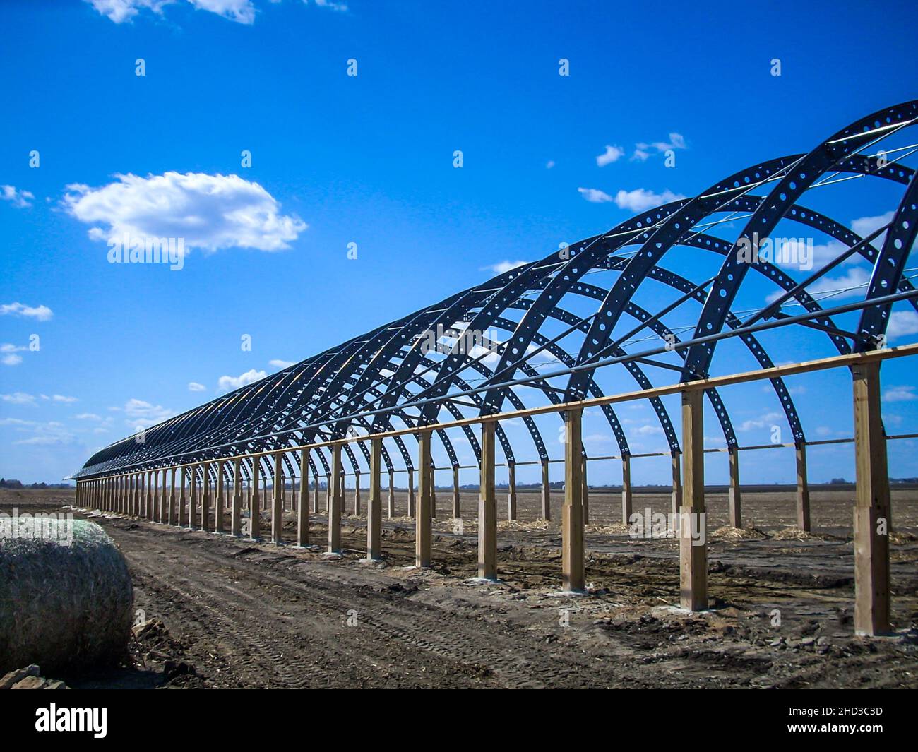 Frame and metal arches of a fabric covered hoop barn under construction ...