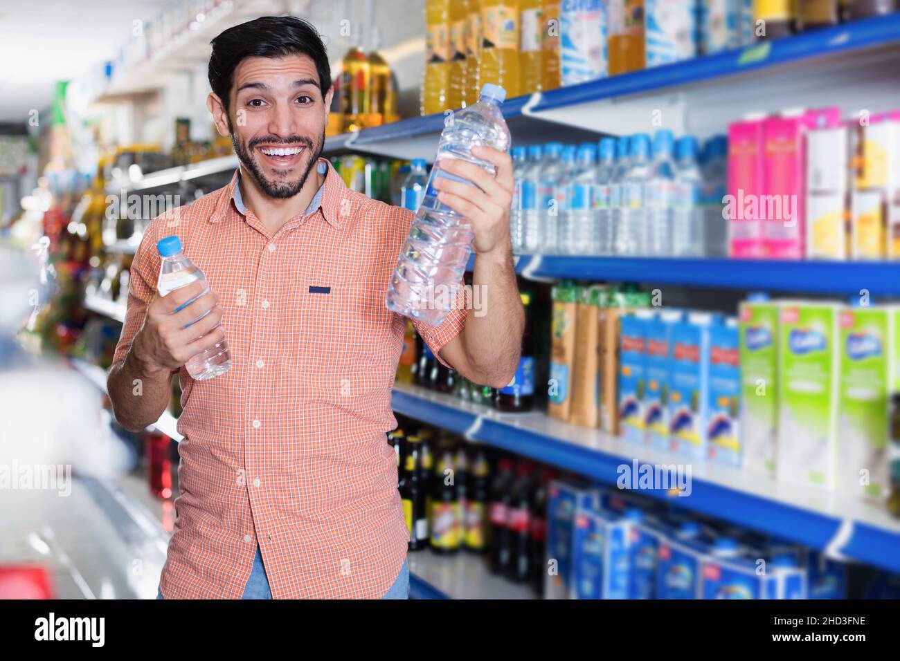 Happy man customer is choosing bottle with water Stock Photo - Alamy