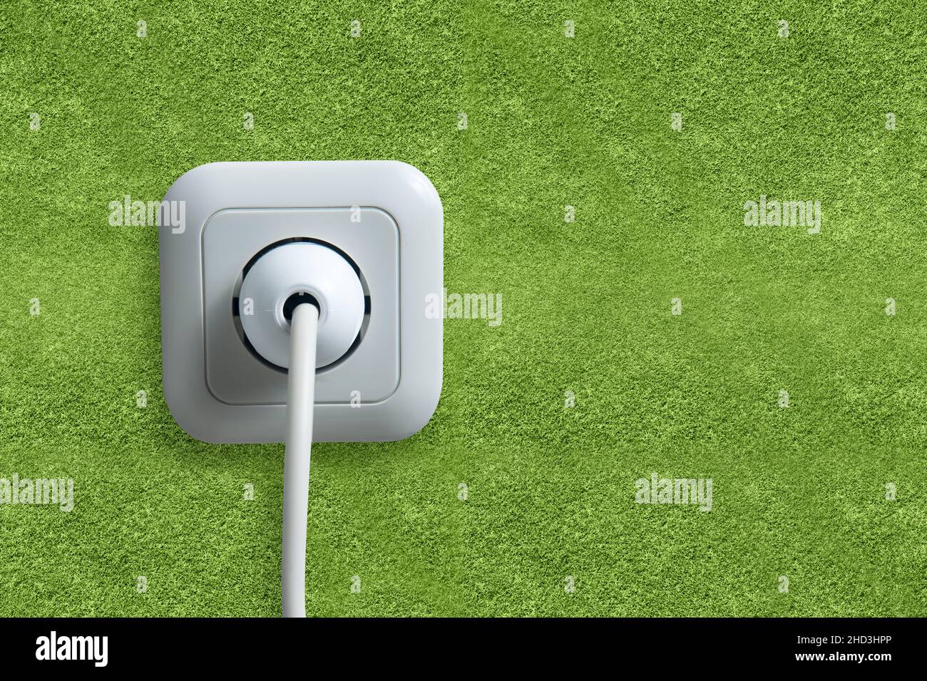 Electric plug into a green wall power socket. Green Power Concept Stock ...