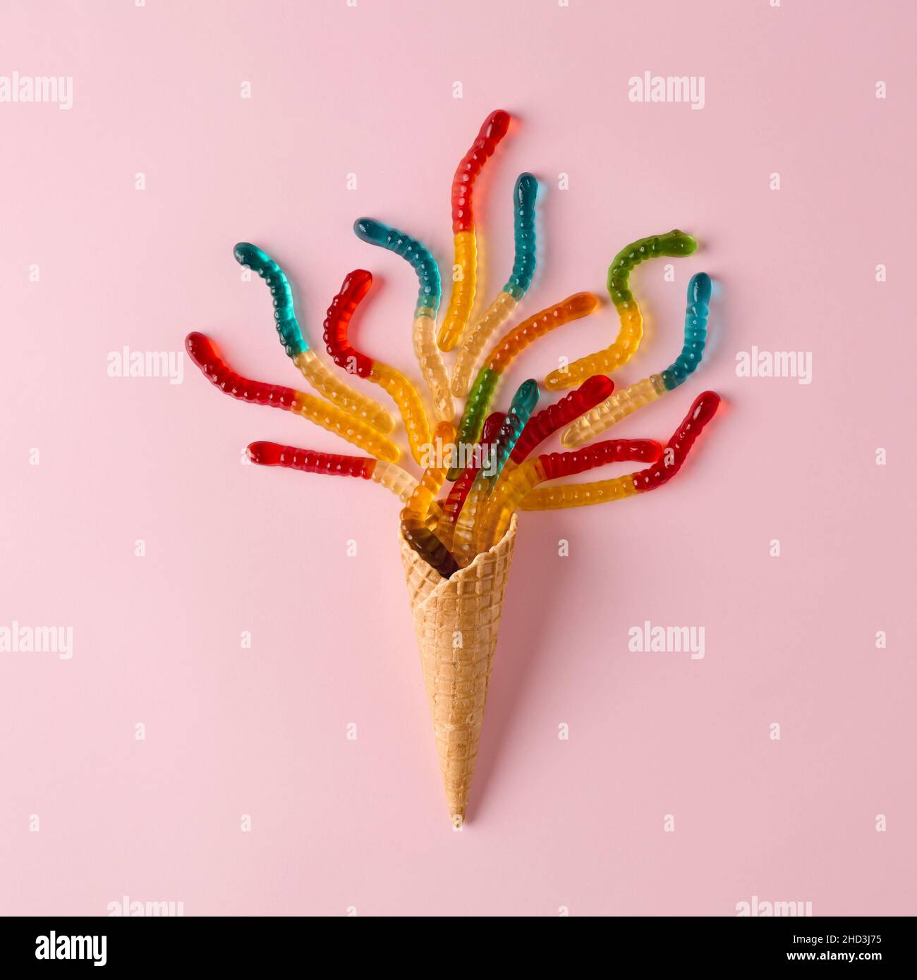 Ice cream cone with gummy candies on pink background. Minimal still ...