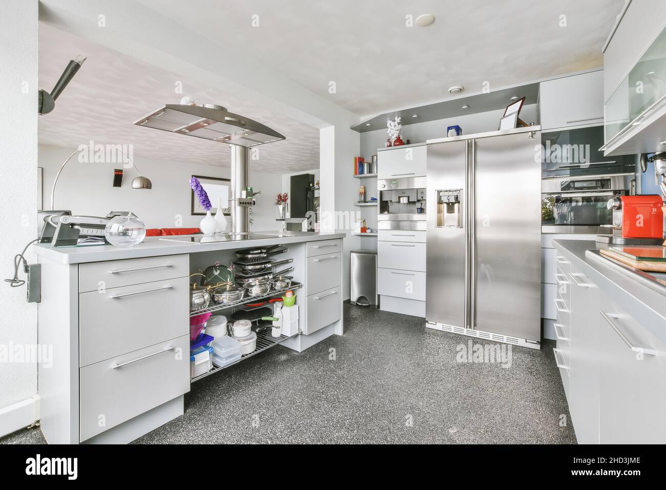 Nice kitchen with a table in the middle and a modern range hood above ...