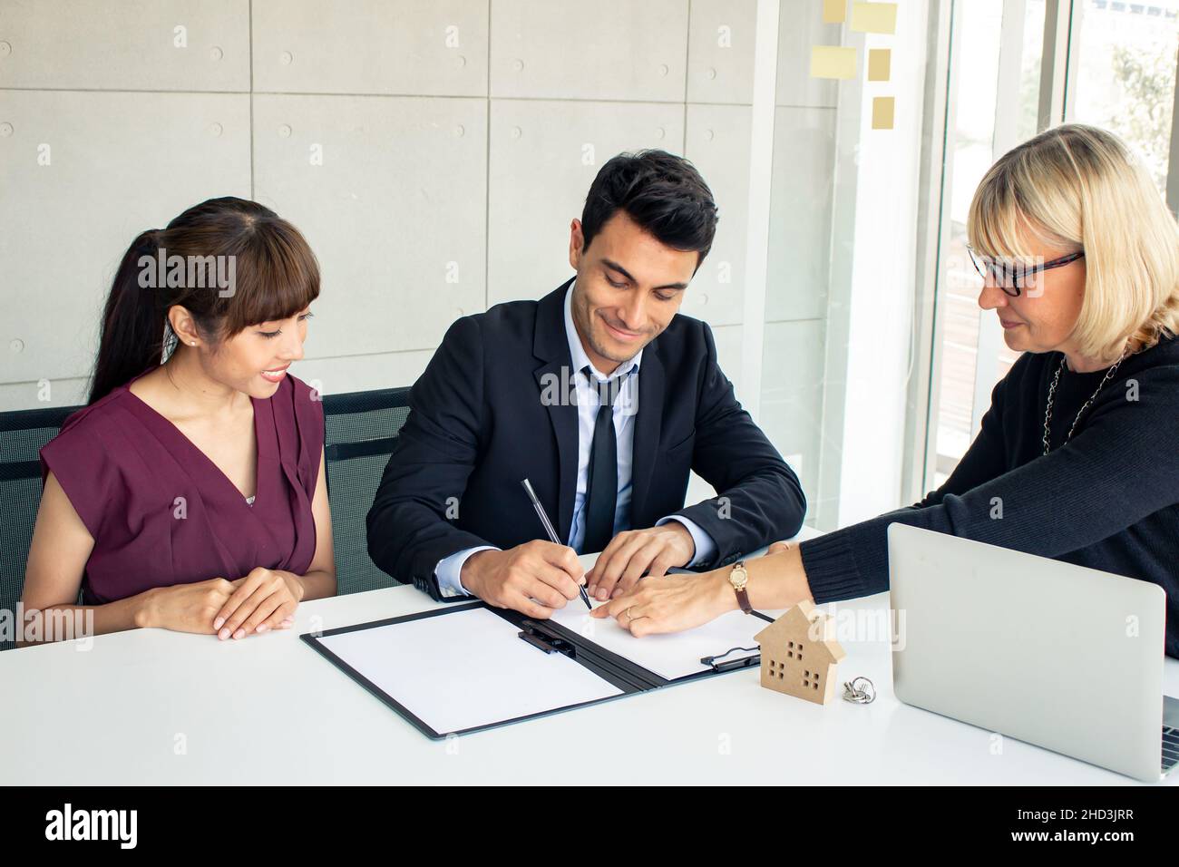 Customers consult with the owner on the contract of house sale. Couples ...