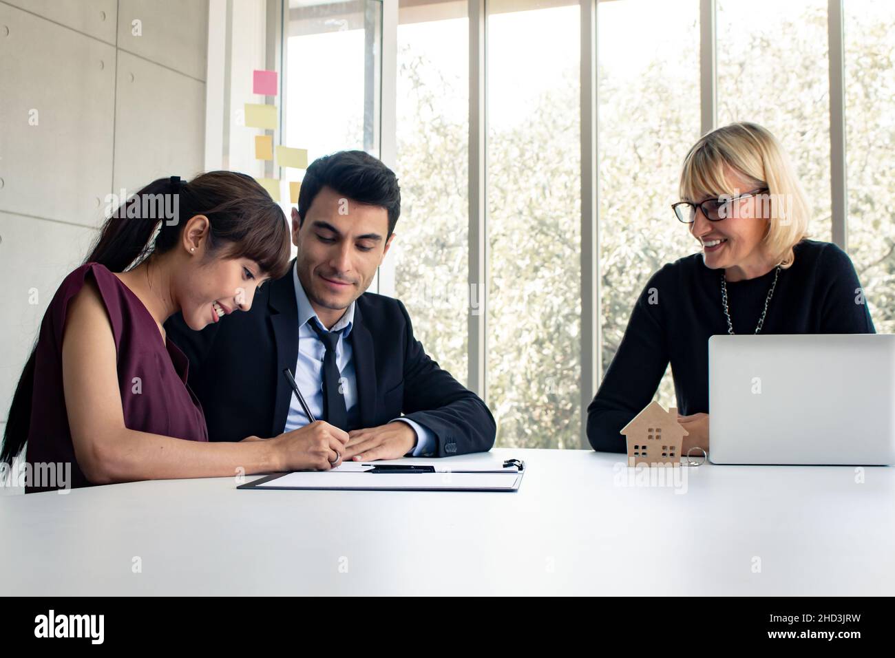 Customers consult with the owner on the contract of house sale. Couples ...