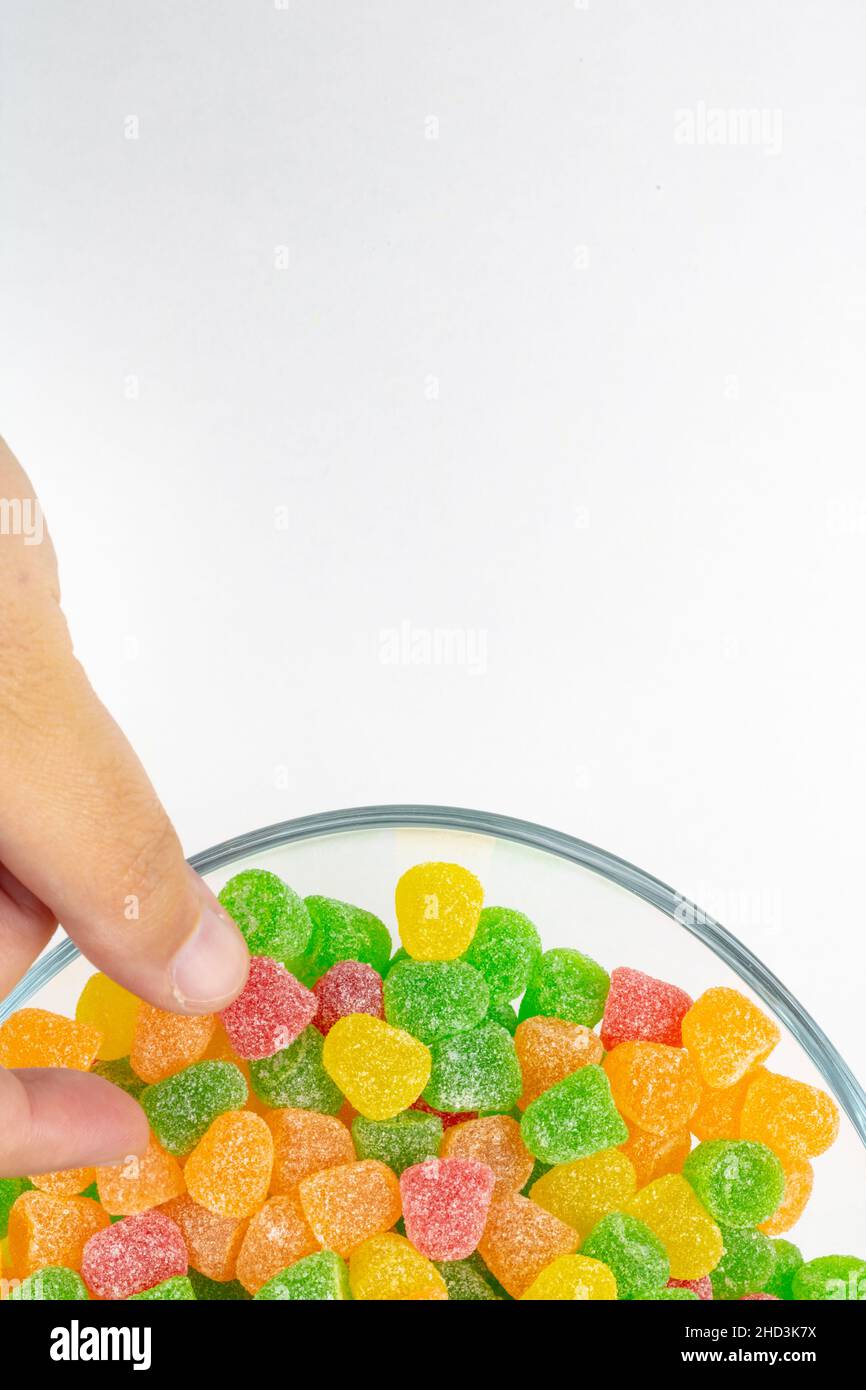 Gummy candies. Picking a jelly candy in a bowl isolated on white ...