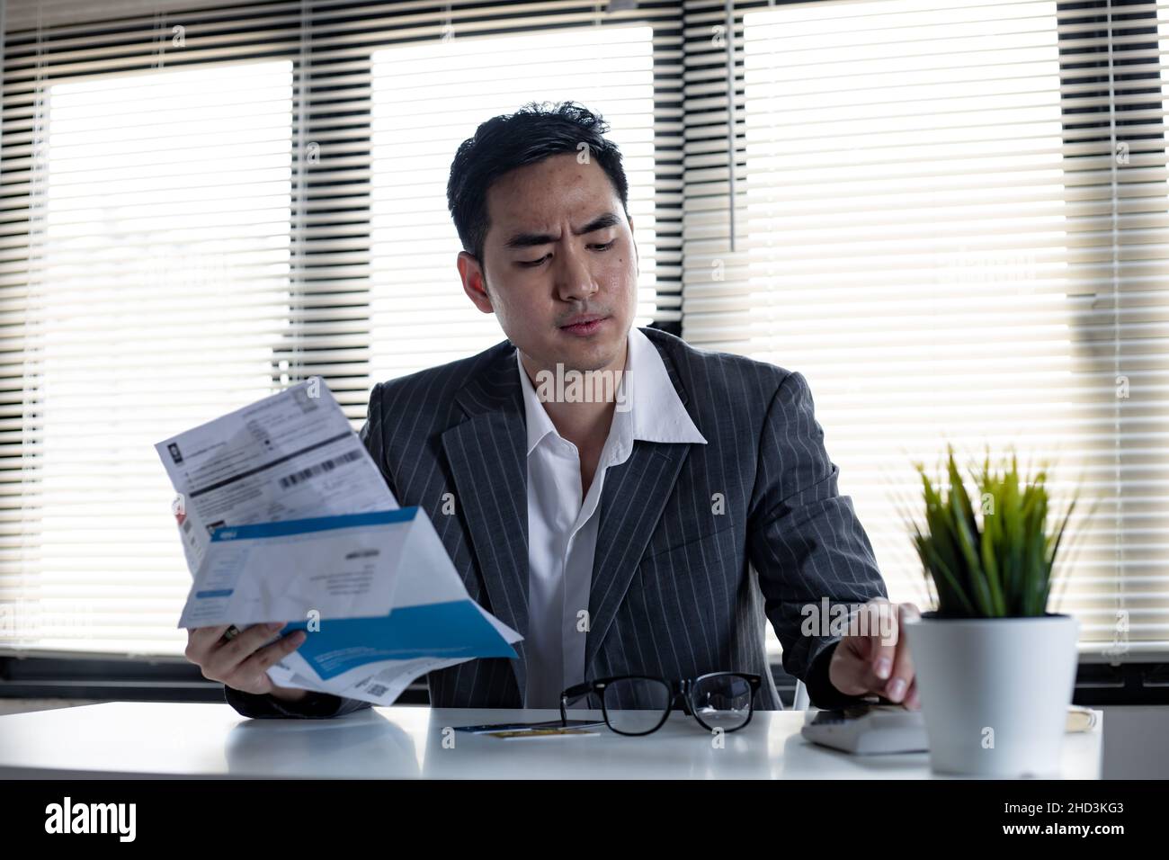 Financial problem concept. Man calculates the debt at hand with a ...