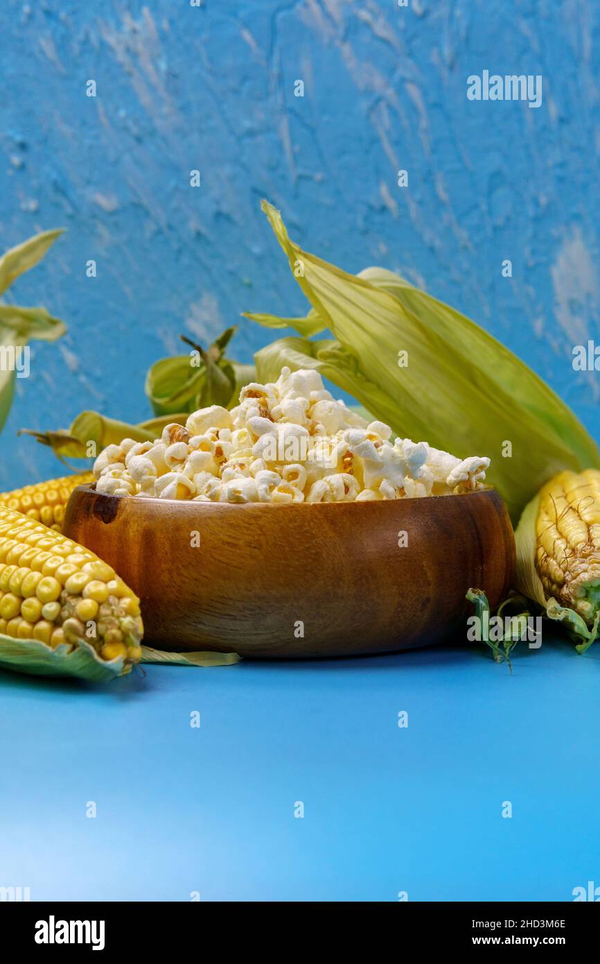 Homemade fresh popped and organic grown dry corn cob against blue ...