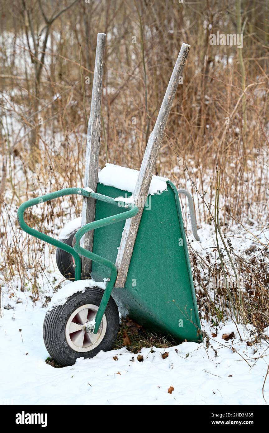 big green wheelbarrow standing in snow in december Stock Photo - Alamy