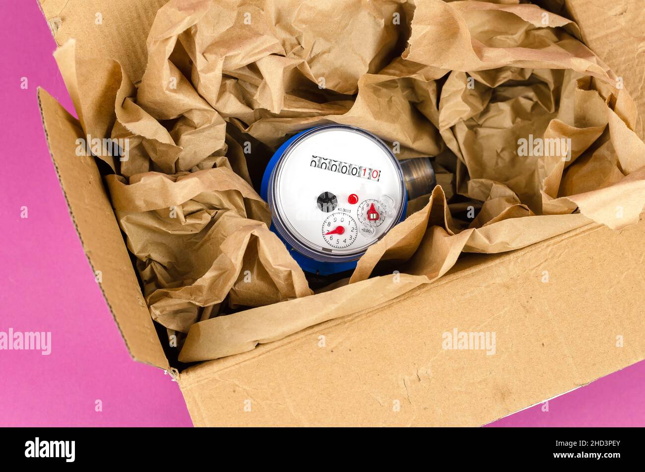 New water meter packed in wrapping paper in a cardboard box. A water ...