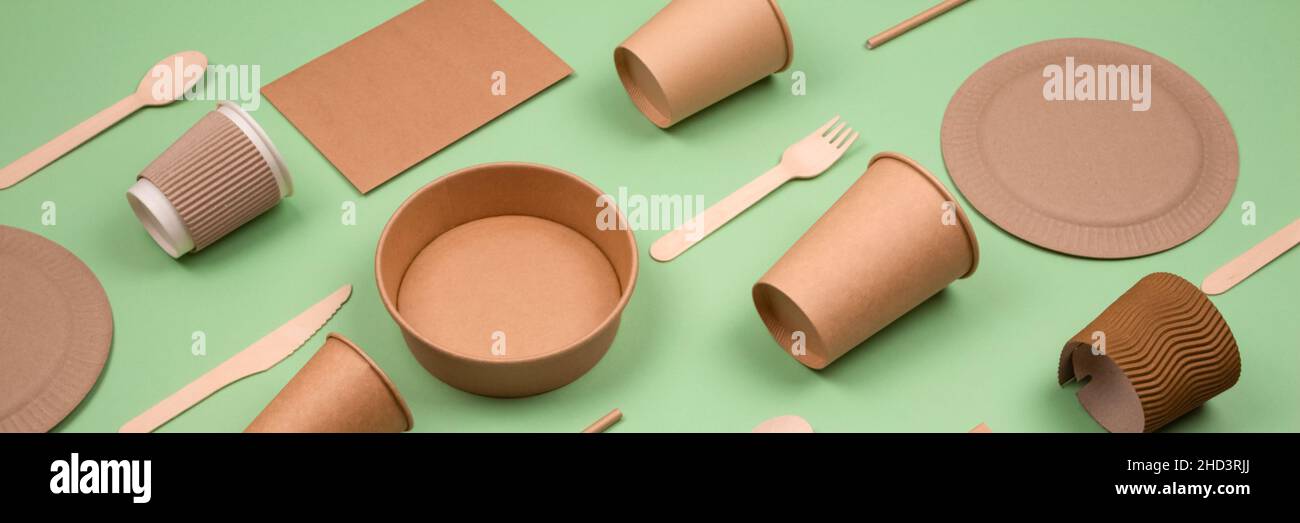 Banner set of different eco-friendly tableware and kraft paper food packaging on green ...