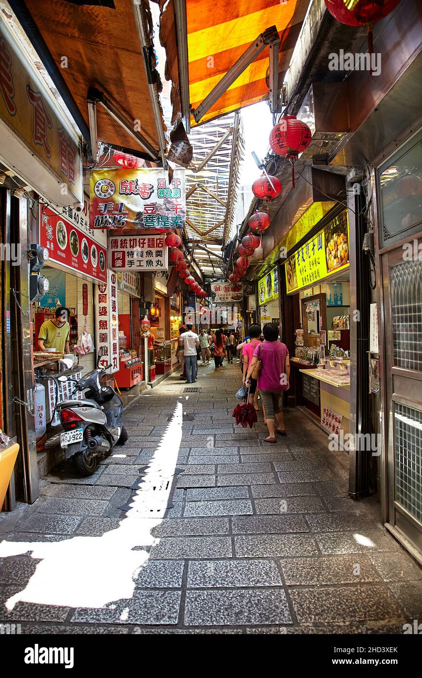 View of a narrow shopping street with retail outlets on both sides in ...