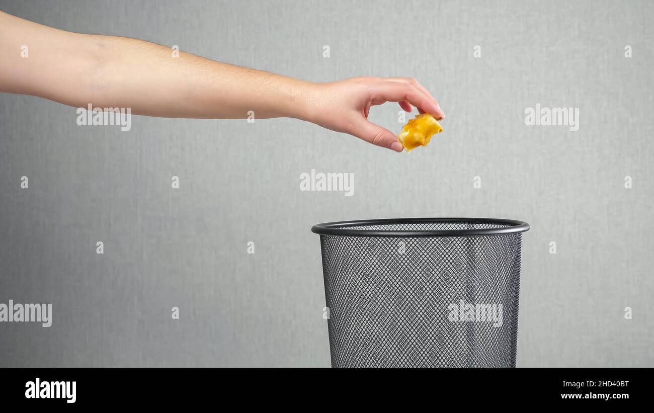 Woman hand throws away apple core into rubbish bin on grey Stock Photo ...