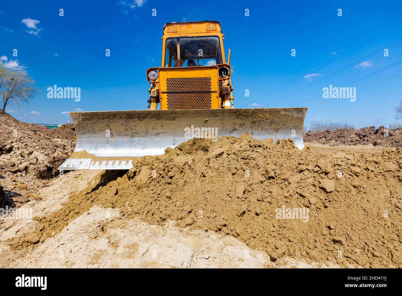Earthmover with caterpillar is moving earth outdoors Stock Photo - Alamy