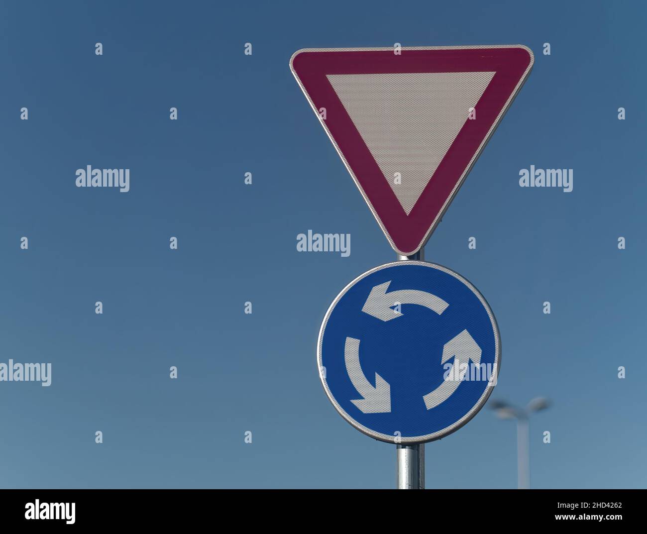 Close-up shot of a yield and roundabout traffic sign attached on a ...