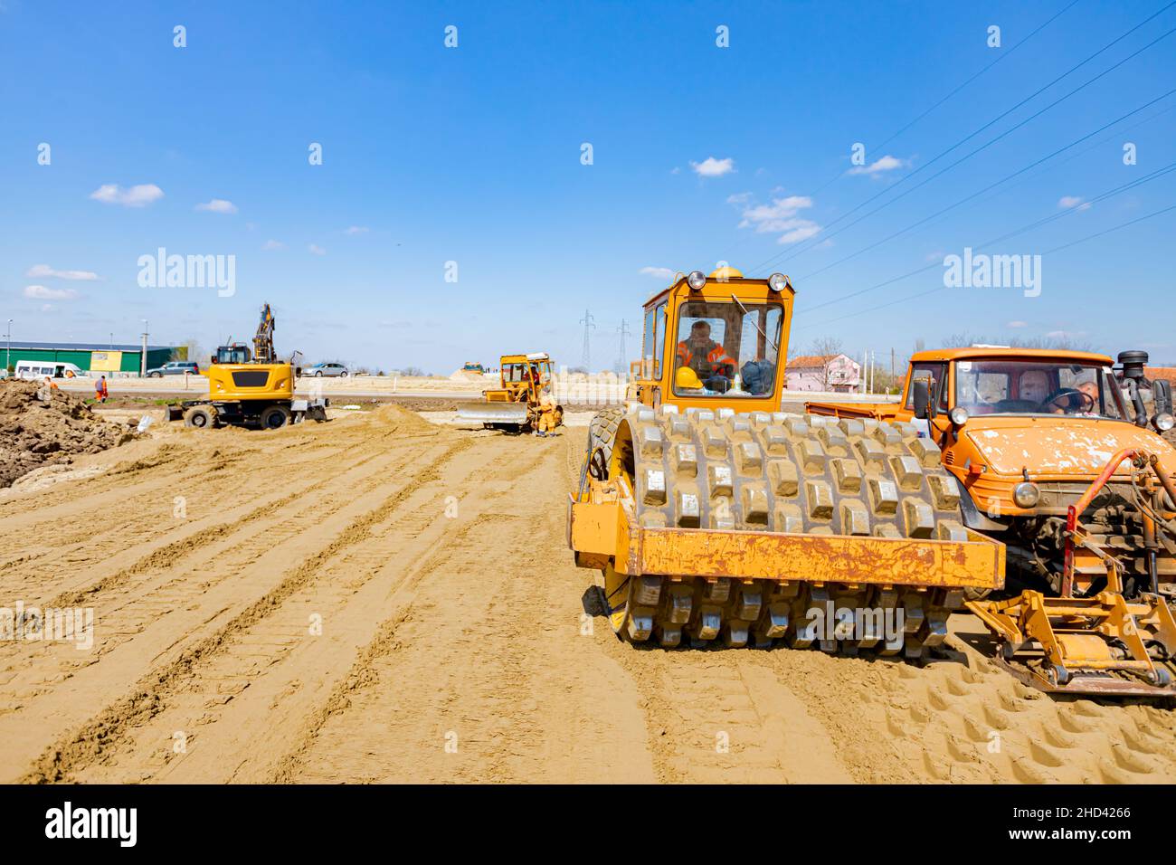 Road roller with spikes and truck with mounted plate vibration ...