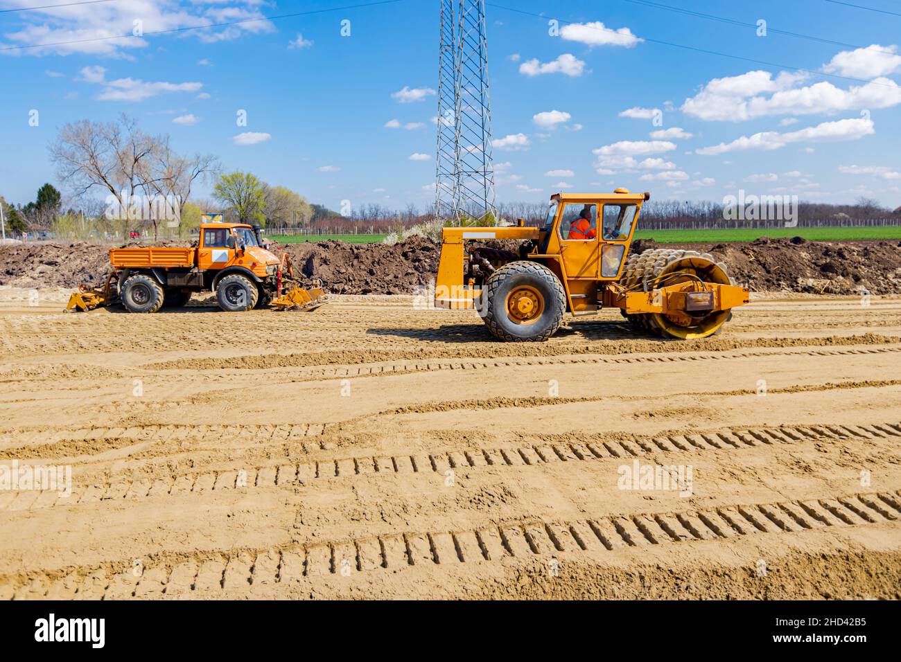 Road roller with spikes and truck with mounted plate vibration ...