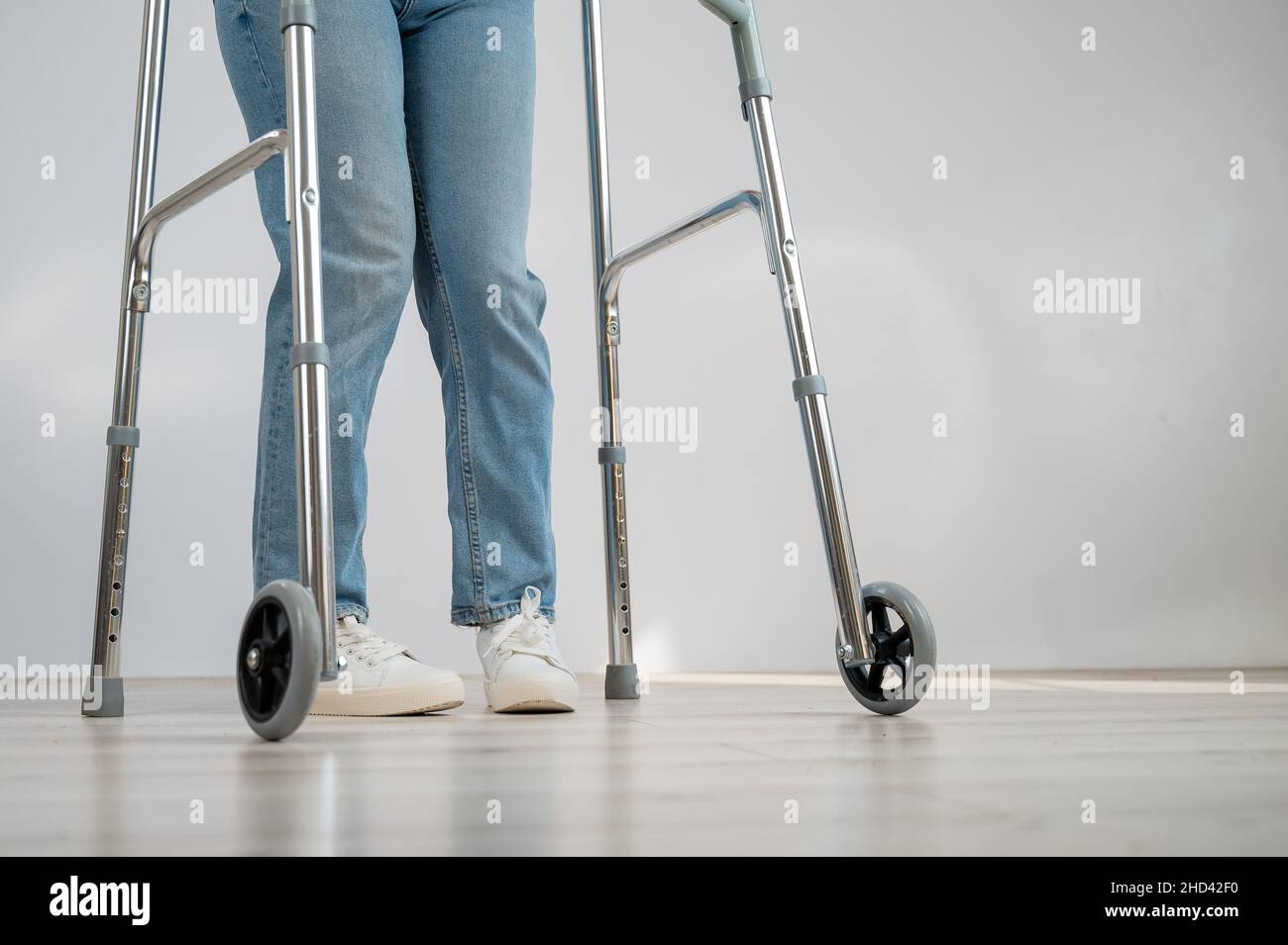 Close-up of female legs with walkers. The girl walks with the help of ...