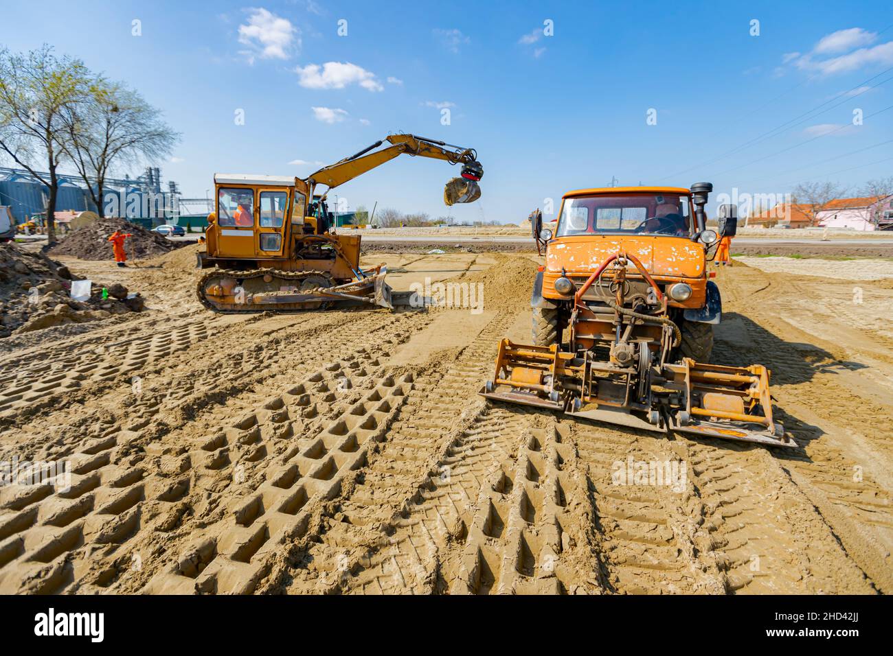 View on excavator and truck with mounted plate vibration compactor, as ...