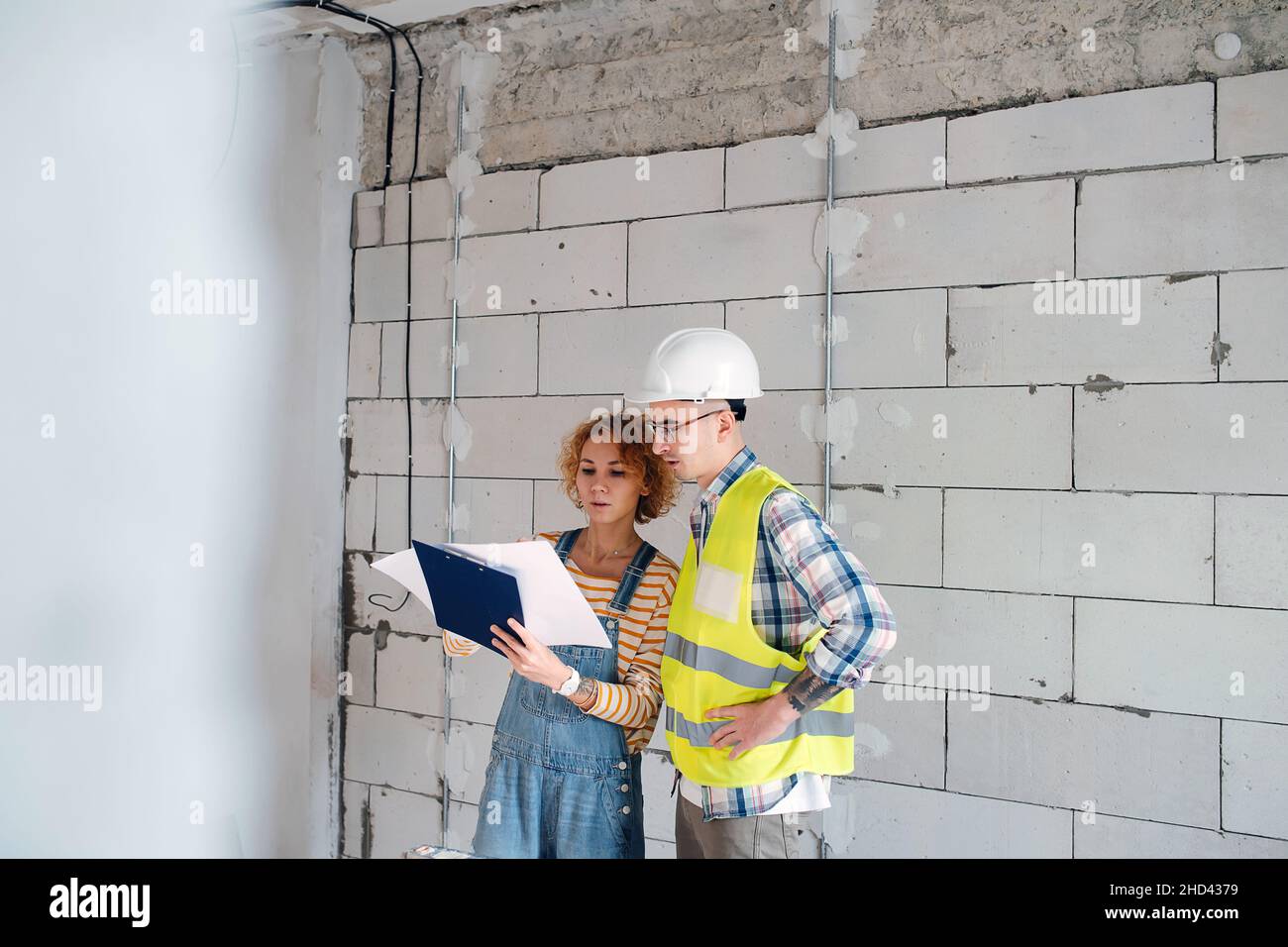 Serious looking engineering team going over a blueprint, discussing it ...