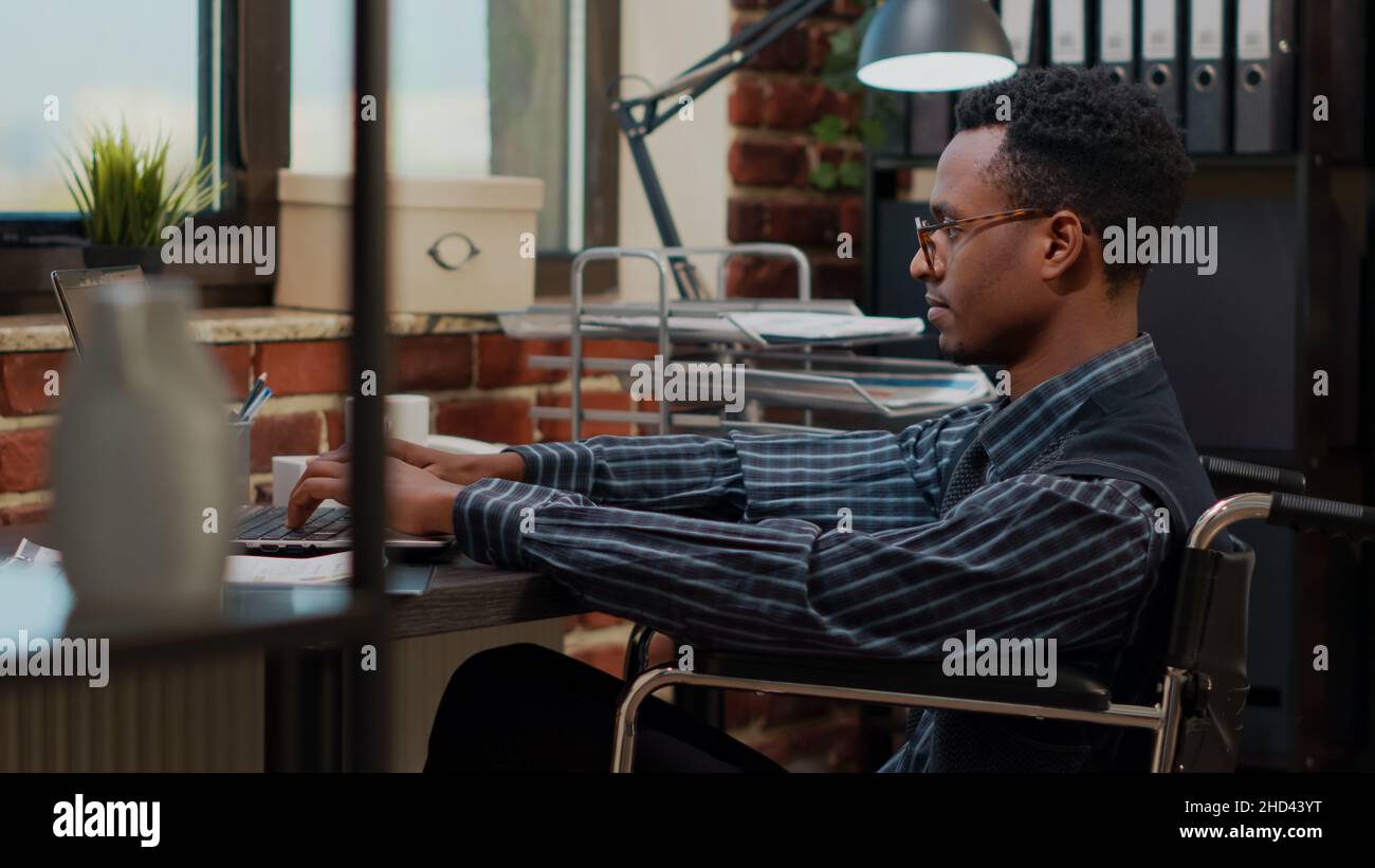 Employee with special needs working on laptop to plan strategy, using e ...