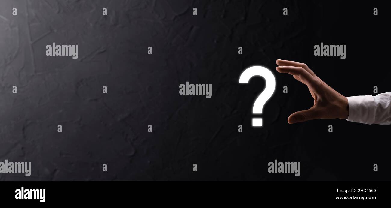 Male hand holding question mark icon on dark background.Banner with ...