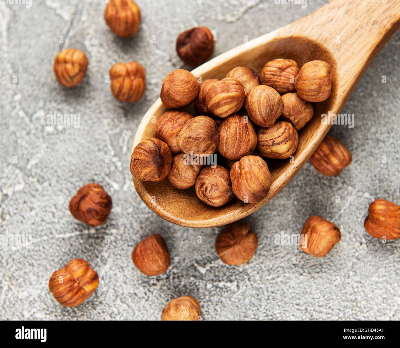 Peeled hazelnuts in a spoon on grey concrete background Stock Photo - Alamy