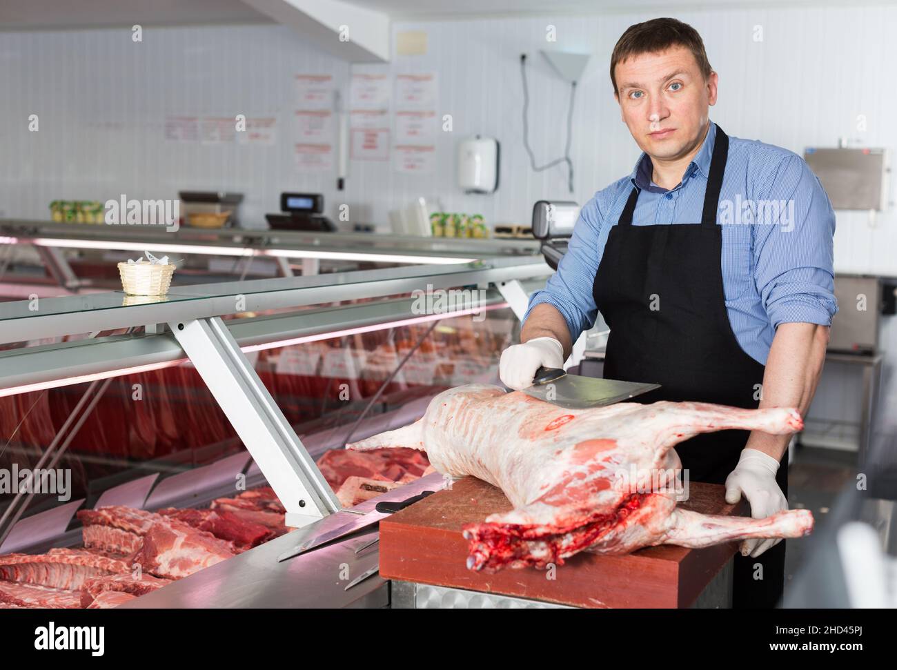 Butcher processing carcase of lamb Stock Photo - Alamy