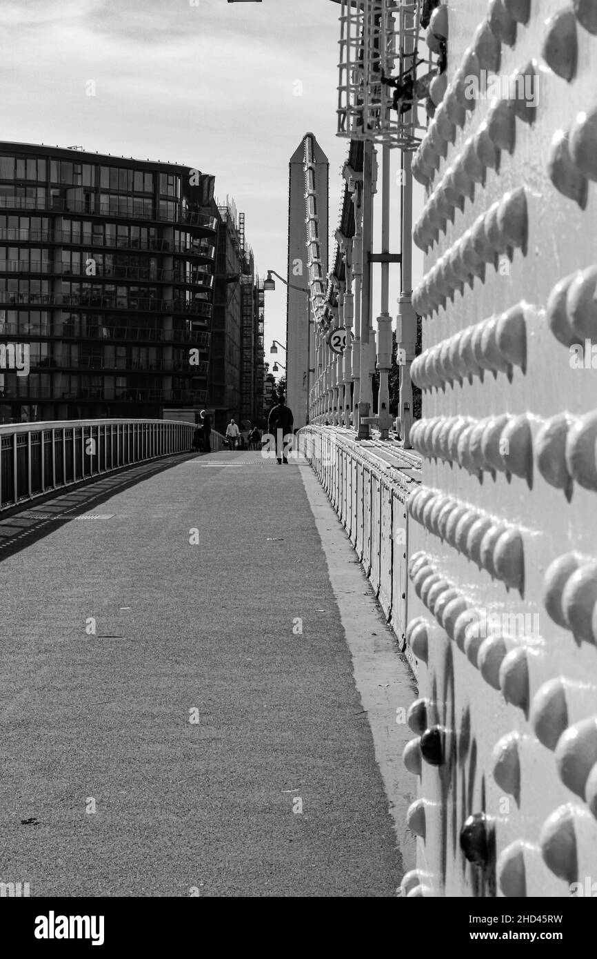 Vertical shot of a narrow path with walking people, grayscale image ...