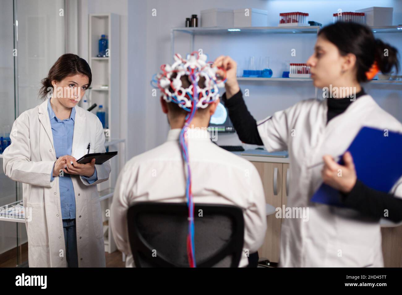 Man patient with eeg headset for activity scan standing in neurological ...