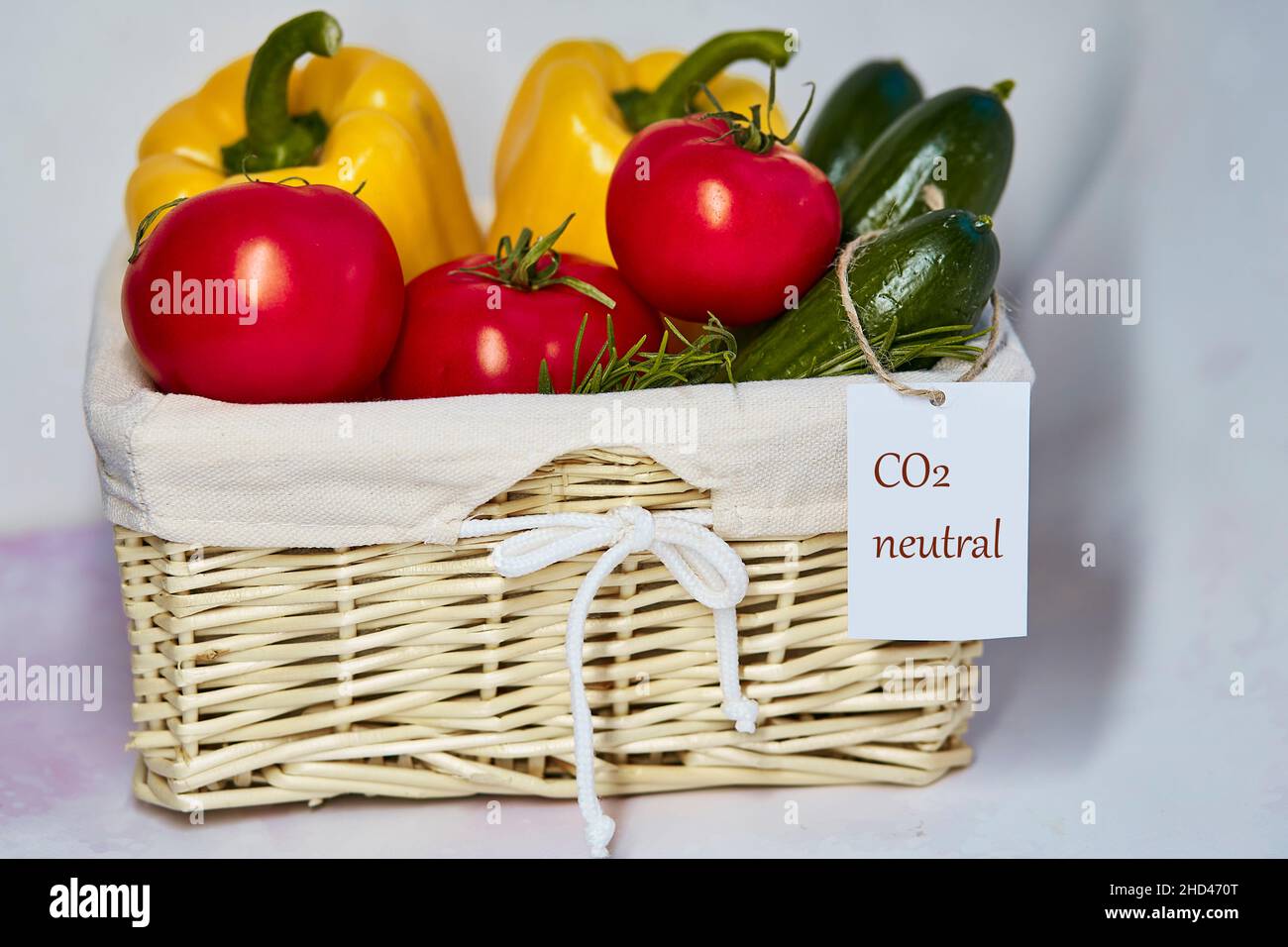 Wicker basket with carbon neutral product label on fresh vegetables ...