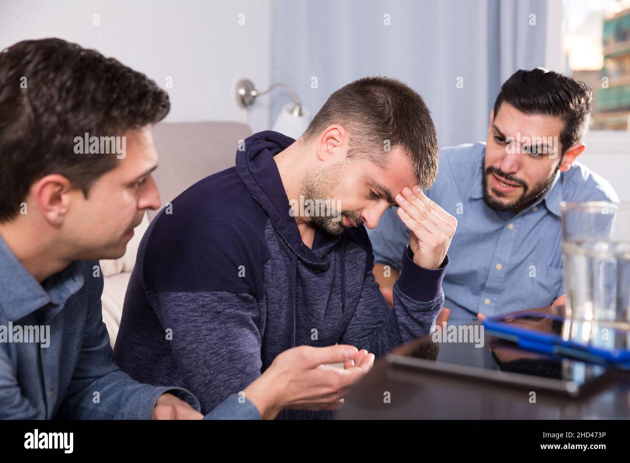 Upset friends talking on couch Stock Photo - Alamy
