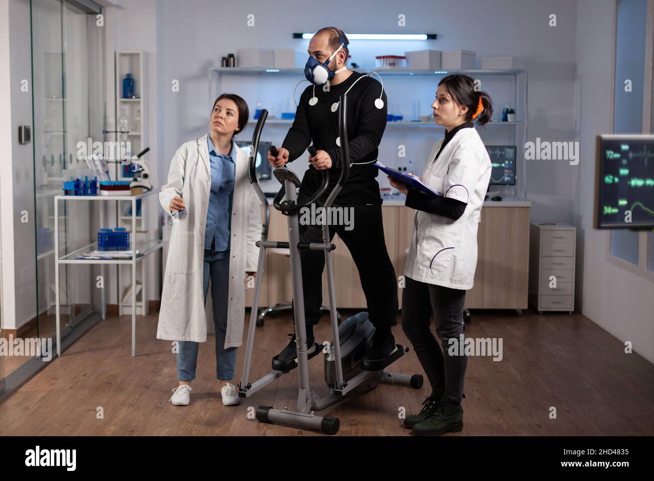 Physician team analyzing body endurance of athlete man during clinical ...