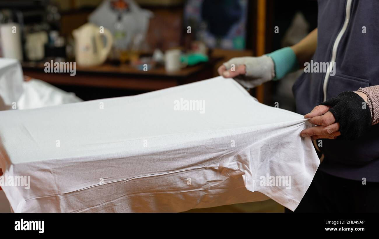 creating print on t-shirt in workshop. serigraphy production. printing ...