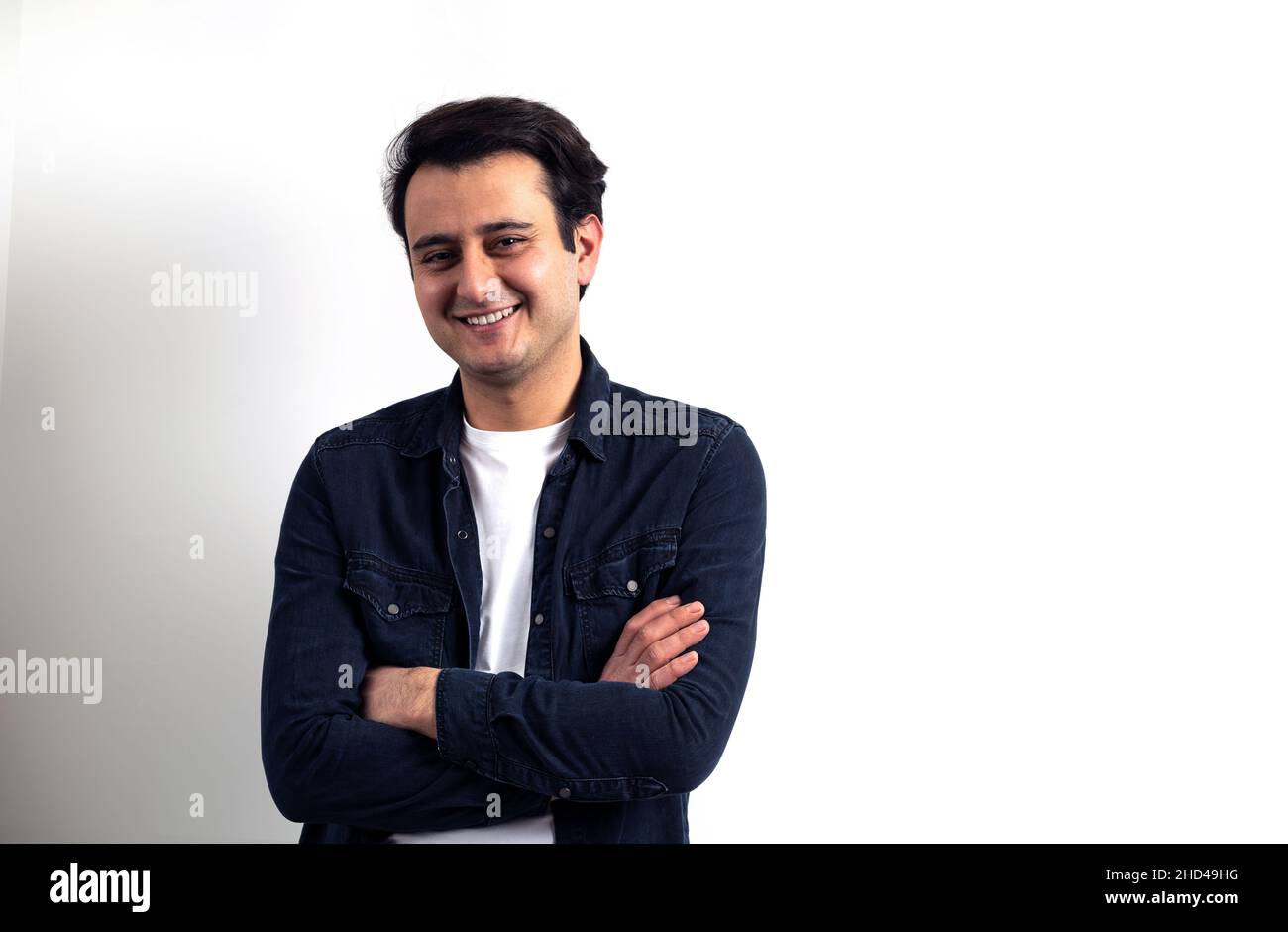 Brown skinned young adult man smiling at camera on isolated white ...