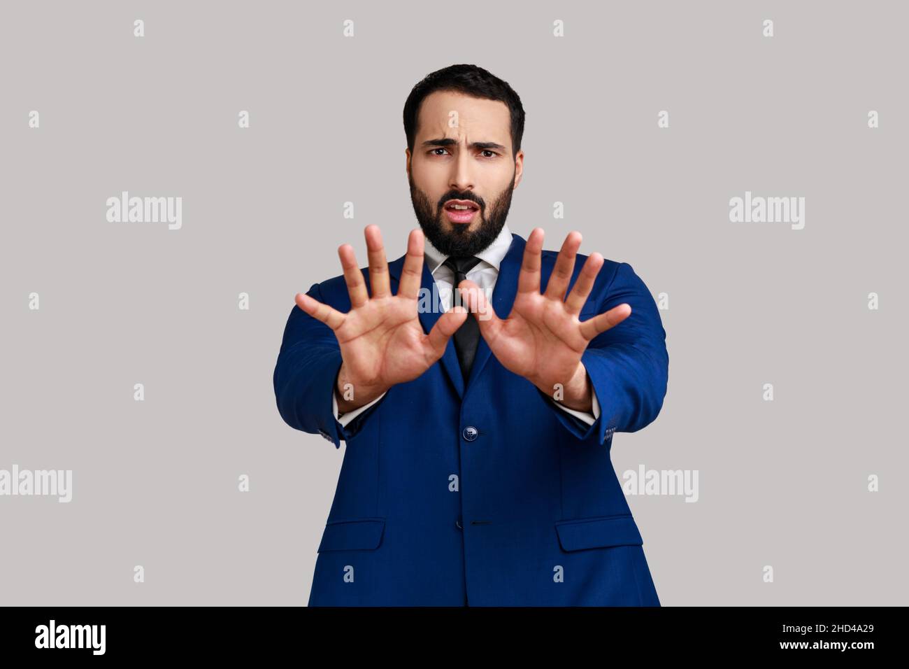 Portrait of bearded man raising hands from sudden fear, looking ...