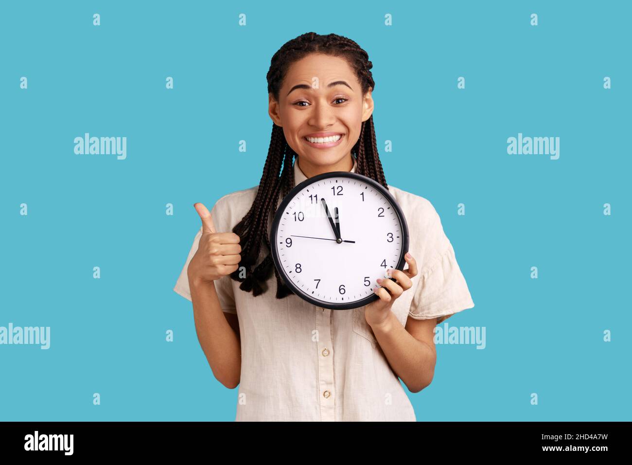 Positive happy woman with dreadlocks showing thumb up holding big wall ...