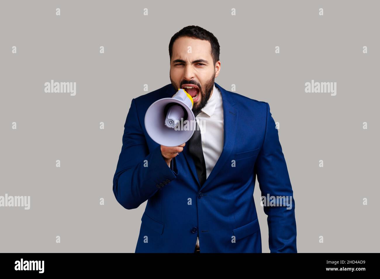 Portrait of young adult handsome bearded man screaming in megaphone ...