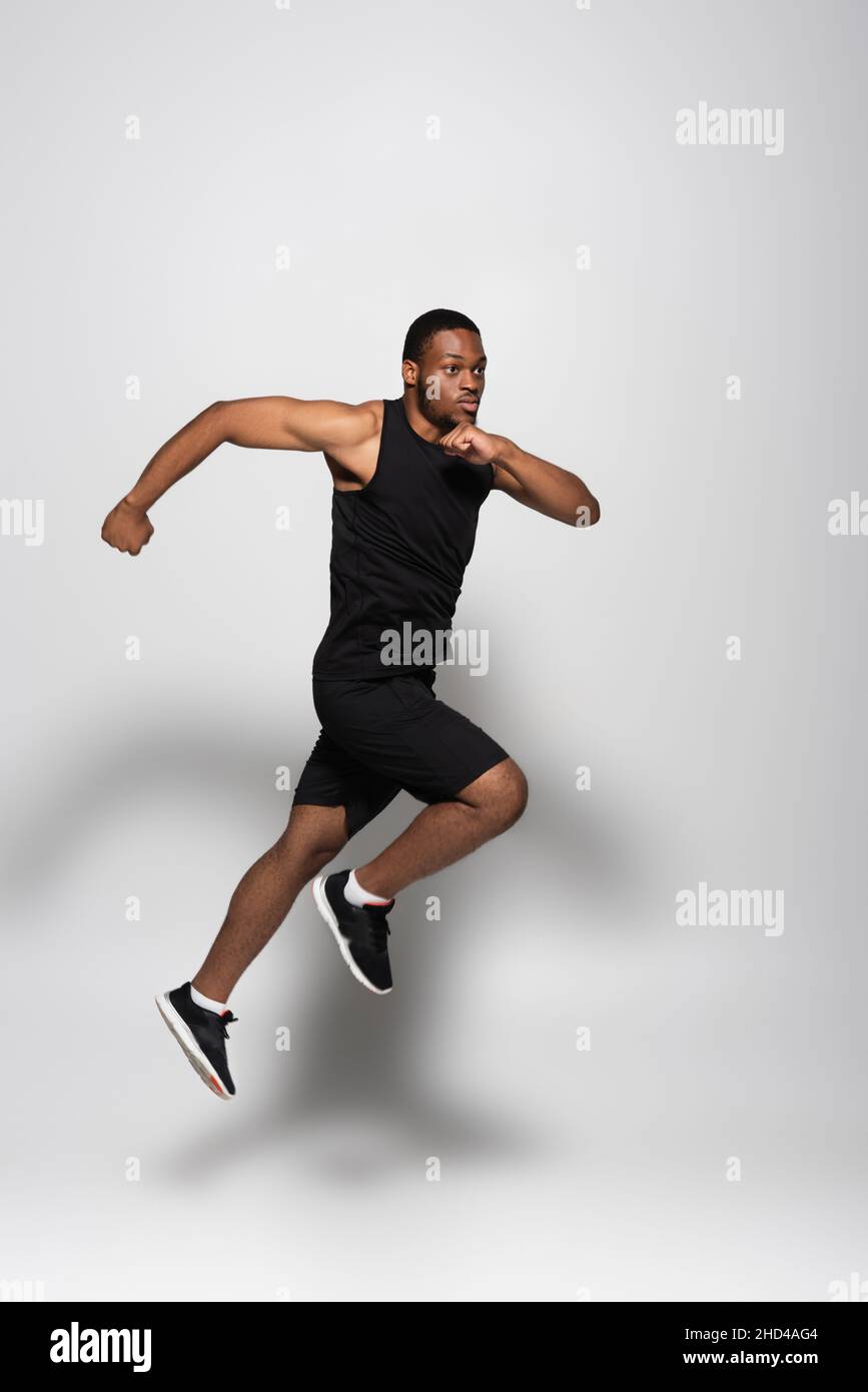 full length of fast african american sportsman levitating while running ...
