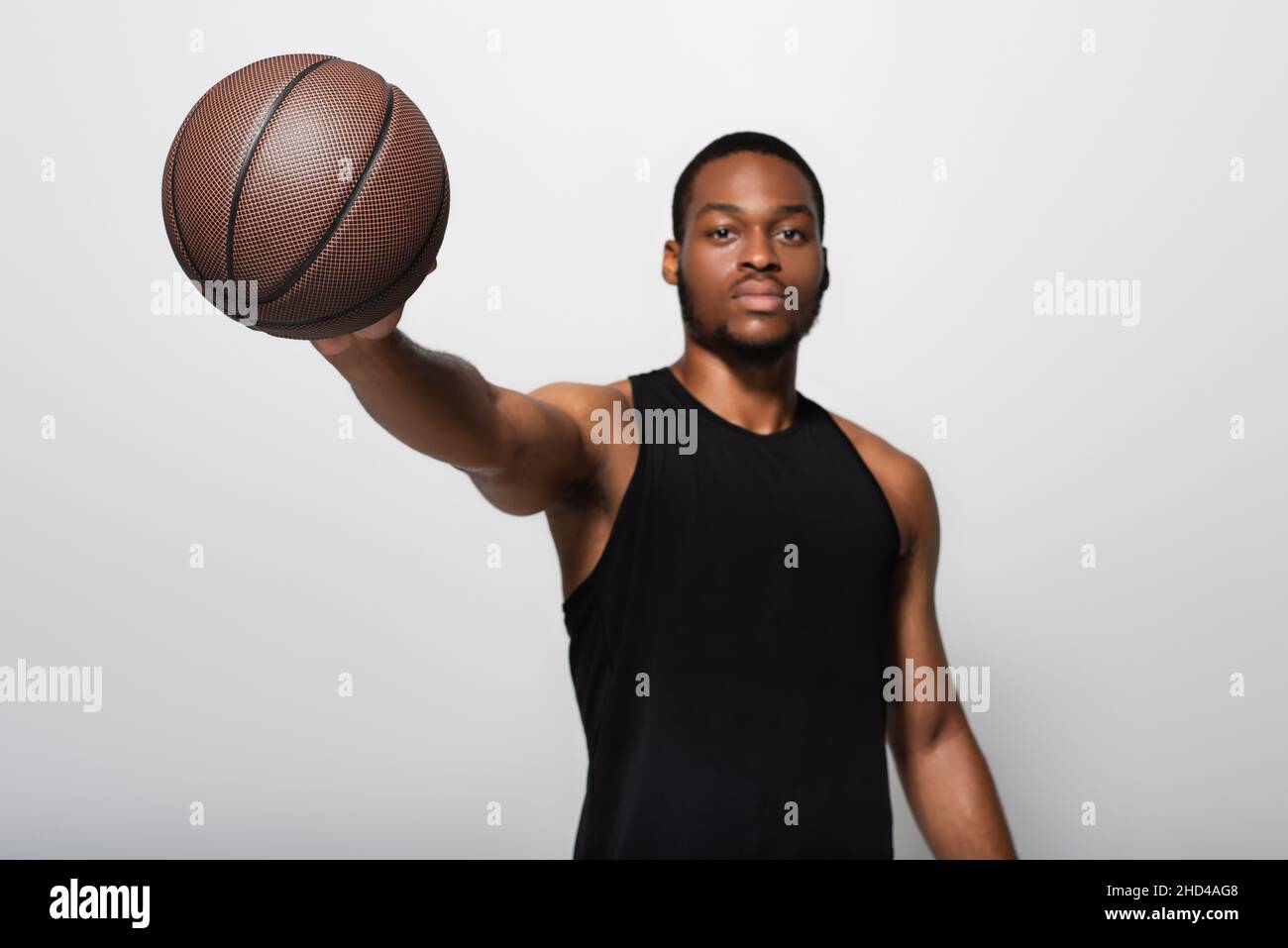 young african american man with outstretched hand holding basketball ...