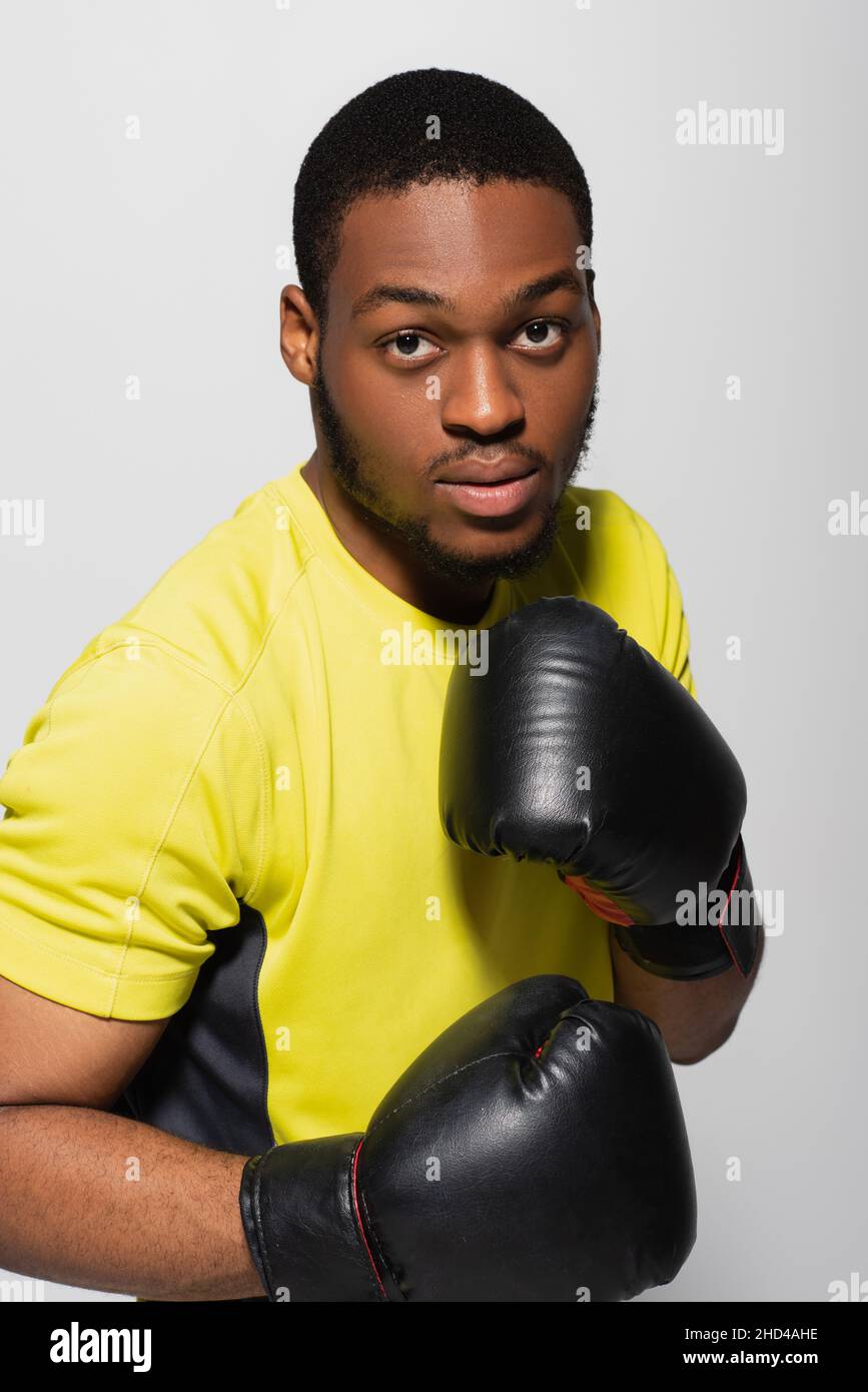 strong african american sportsman in boxing gloves isolated on grey ...