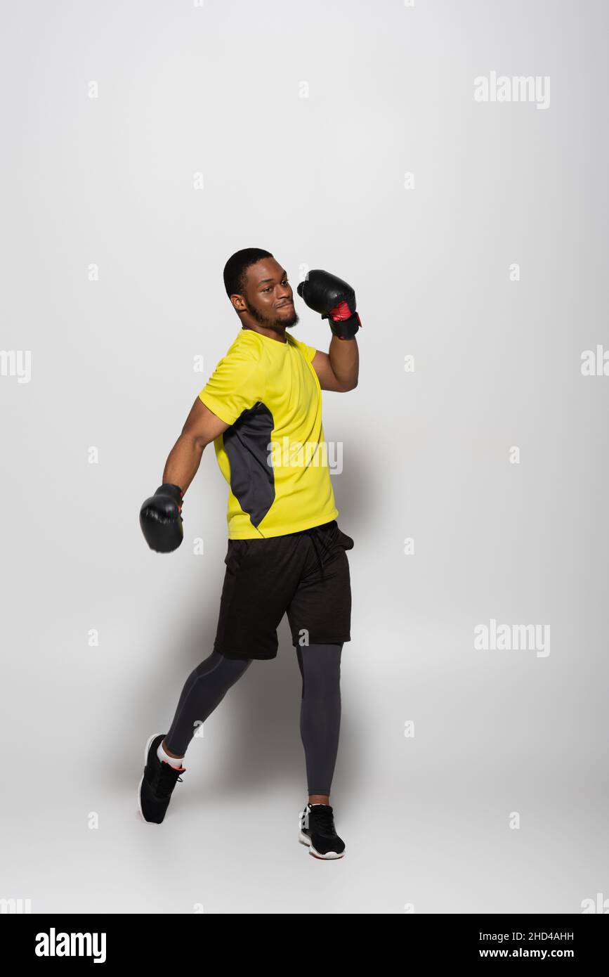 full length of strong african american sportsman in boxing gloves ...