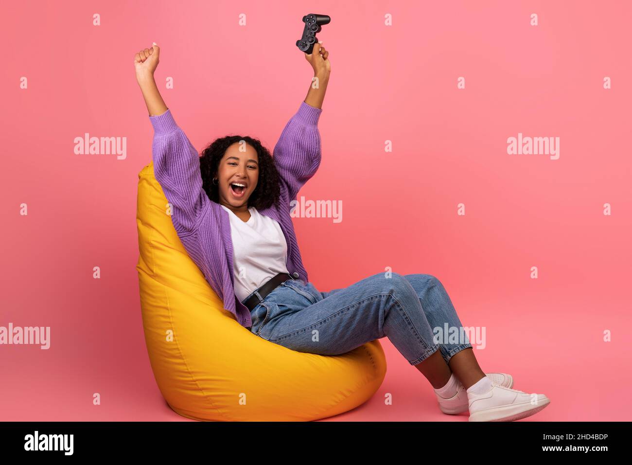 Excited black female gamer with joystick gesturing YES, feeling happy ...