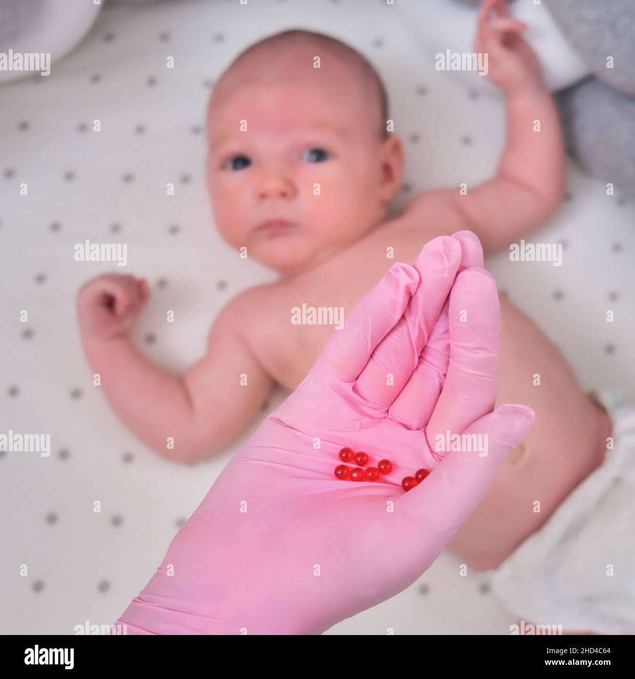 The doctor prescribes pills for a newborn child. A nurse in uniform ...