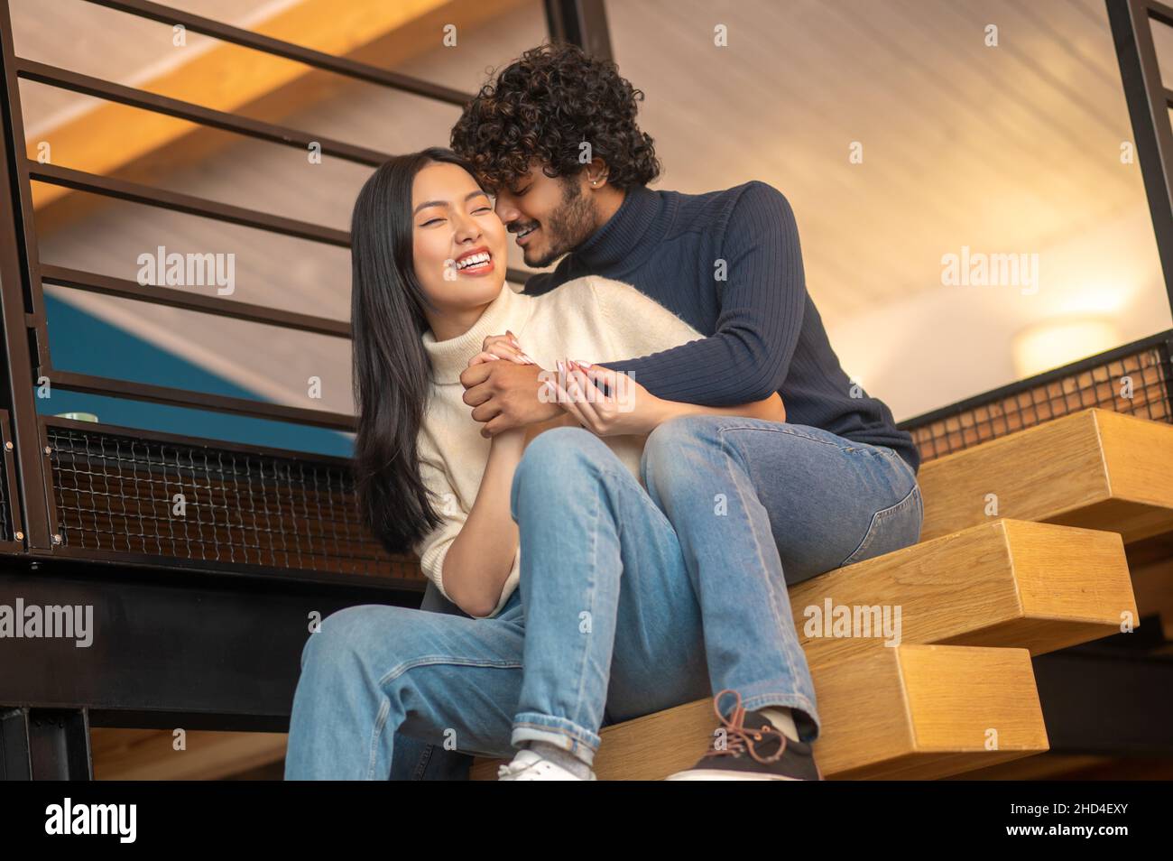 Man hugging whispering in ear of woman Stock Photo - Alamy