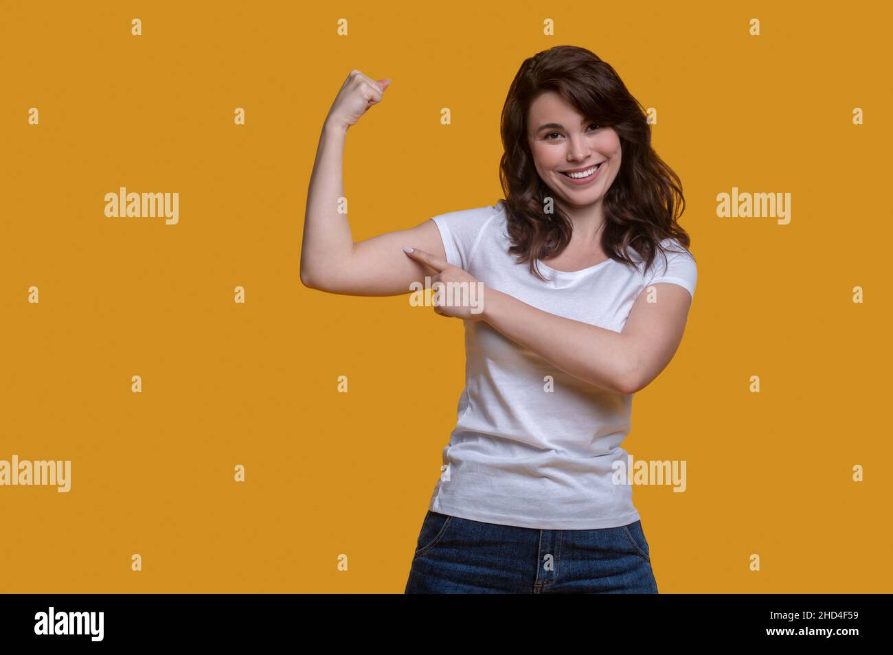 Energetic sporty lady flexing her arm muscles Stock Photo - Alamy