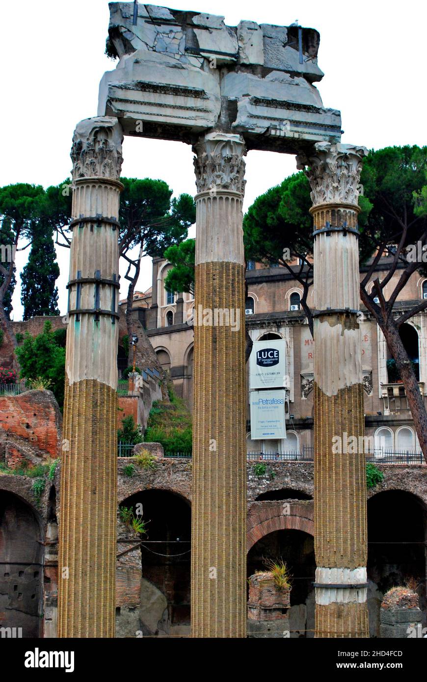 Vertical shot of a ruined stone ancient columns in Pompeii, Campania, Italy against a cloudy sky ...