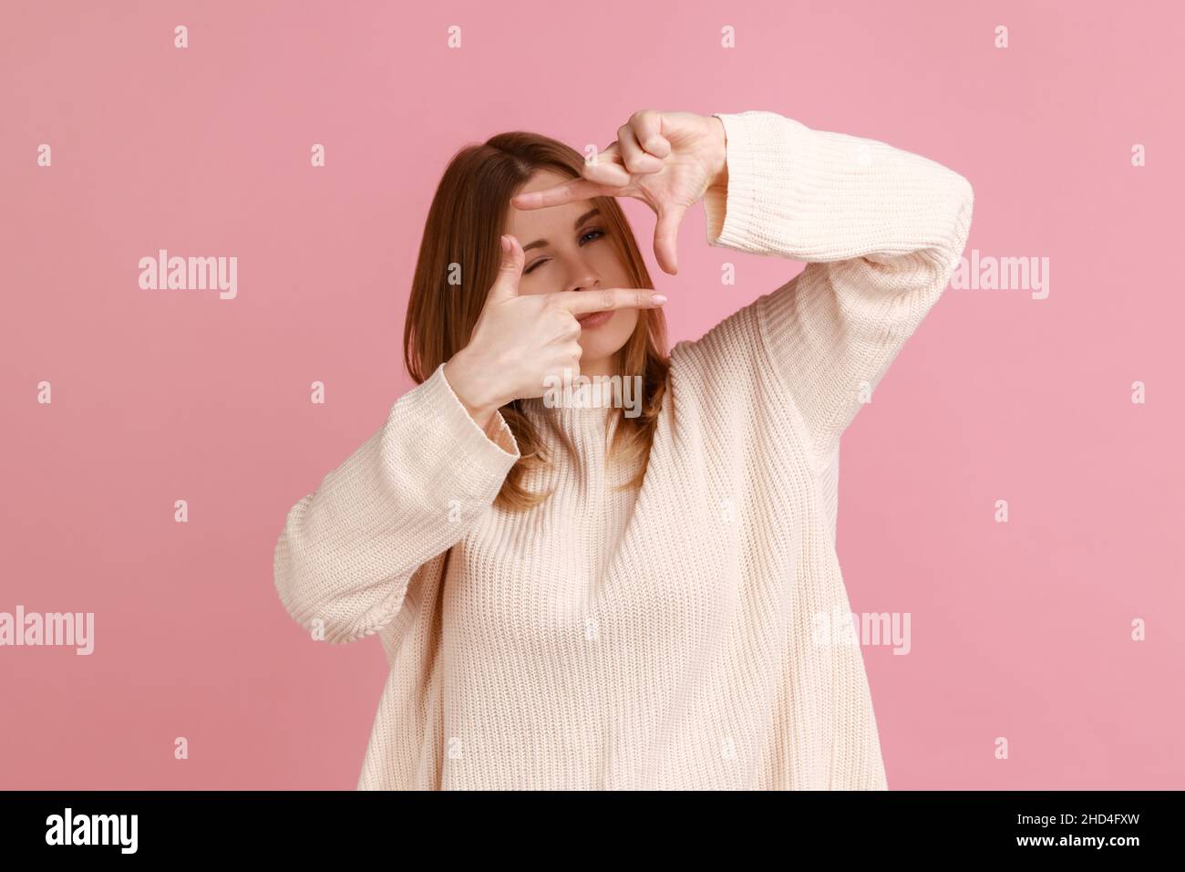 Portrait of blond woman imitating to take picture, looking through ...