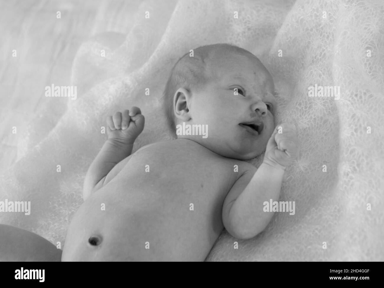 Newborn baby girl lies on the bed. The baby has just turned two weeks ...